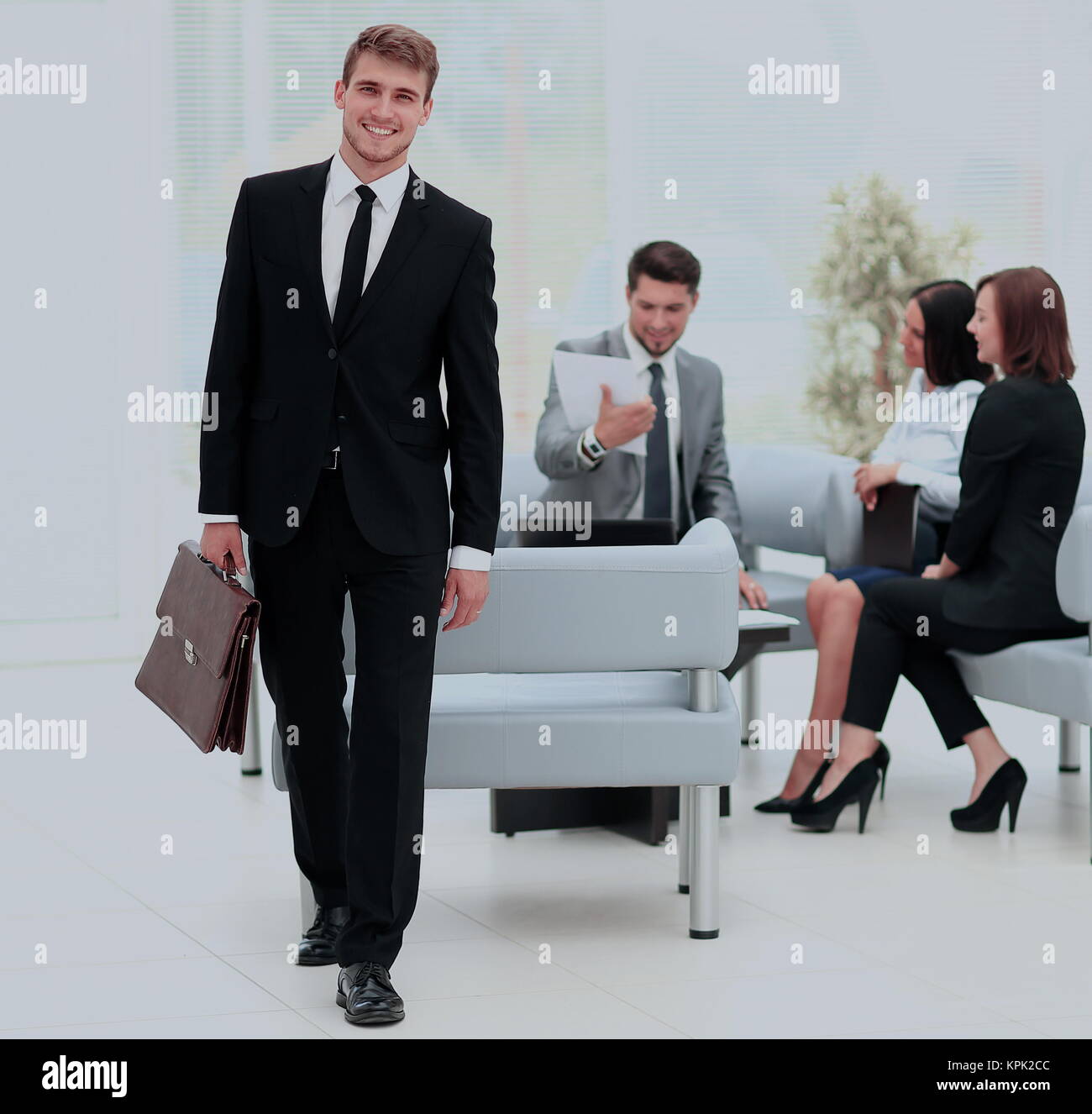 Successful business man standing with his staff in background at Stock ...