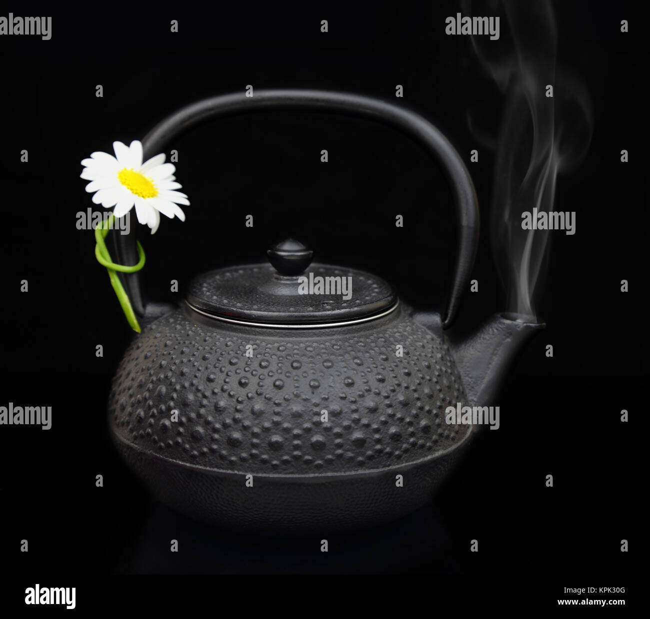 Teapot with chamomile flower and smoke isolated on black Stock Photo ...