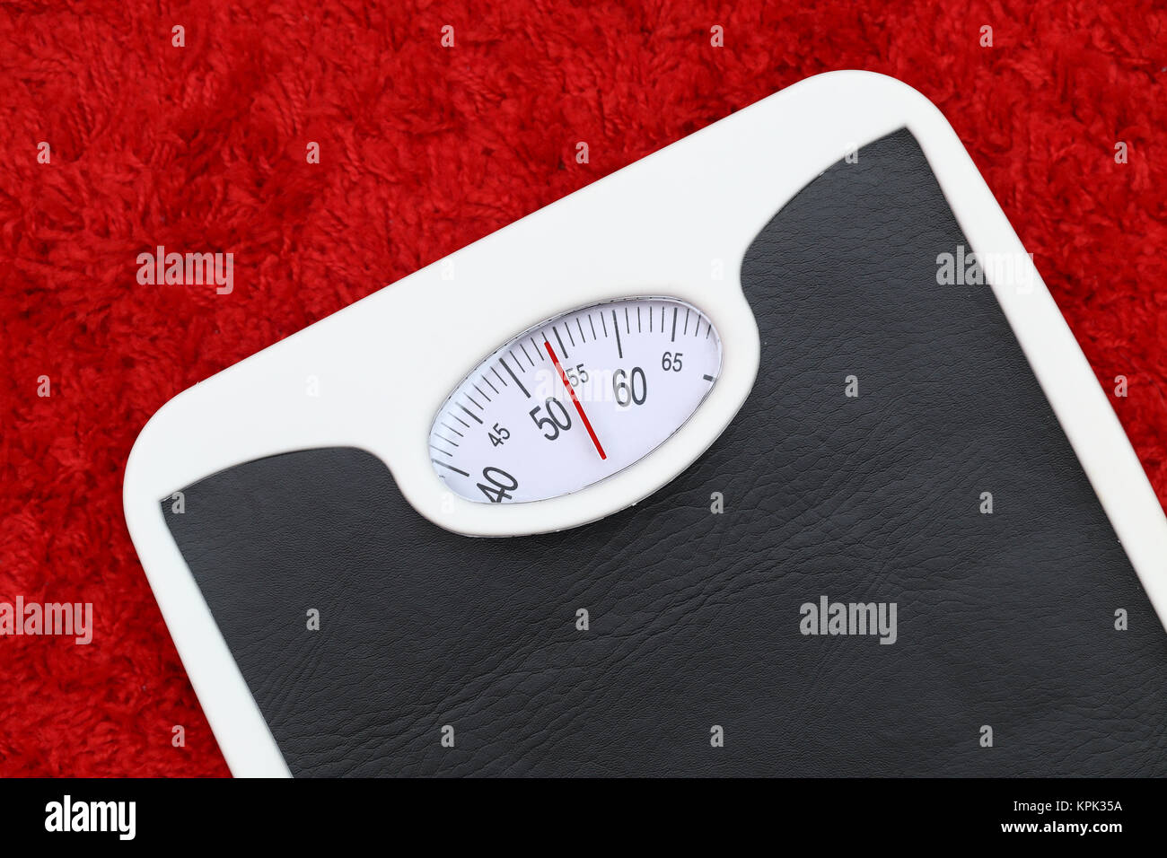 Bathroom scale on red bath mat Stock Photo - Alamy