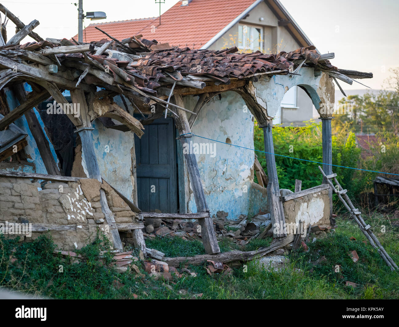 A house in disrepair with the roof torn to pieces and the pillars in ...