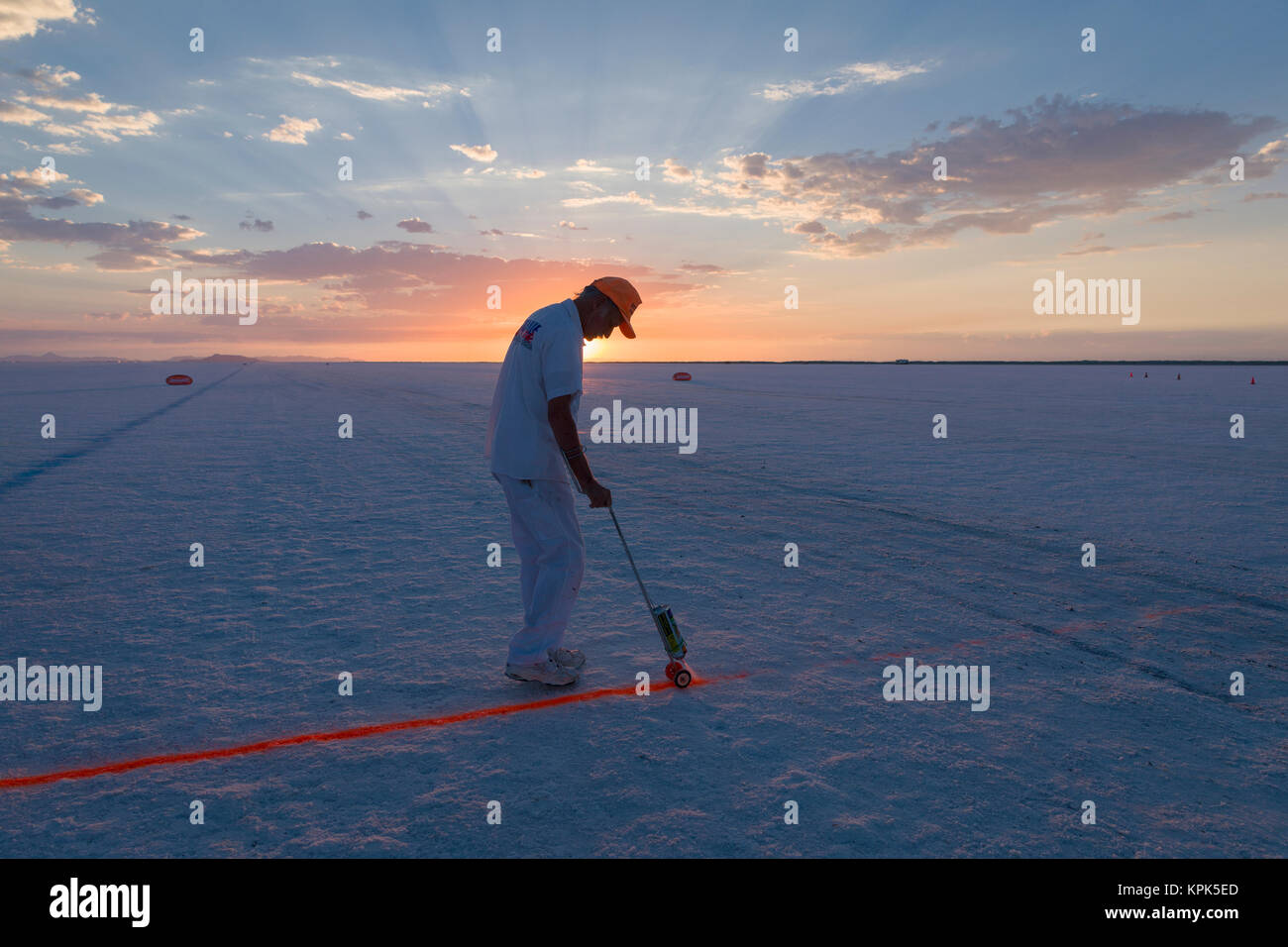 Race official sprays starting line at sunrise on Bonneville Salt Flats ...