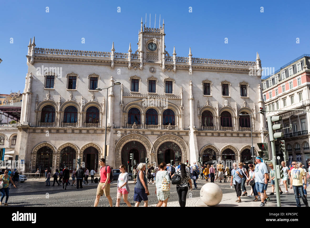 People in front of the Neo-Manueline style facade of Rossio railway ...