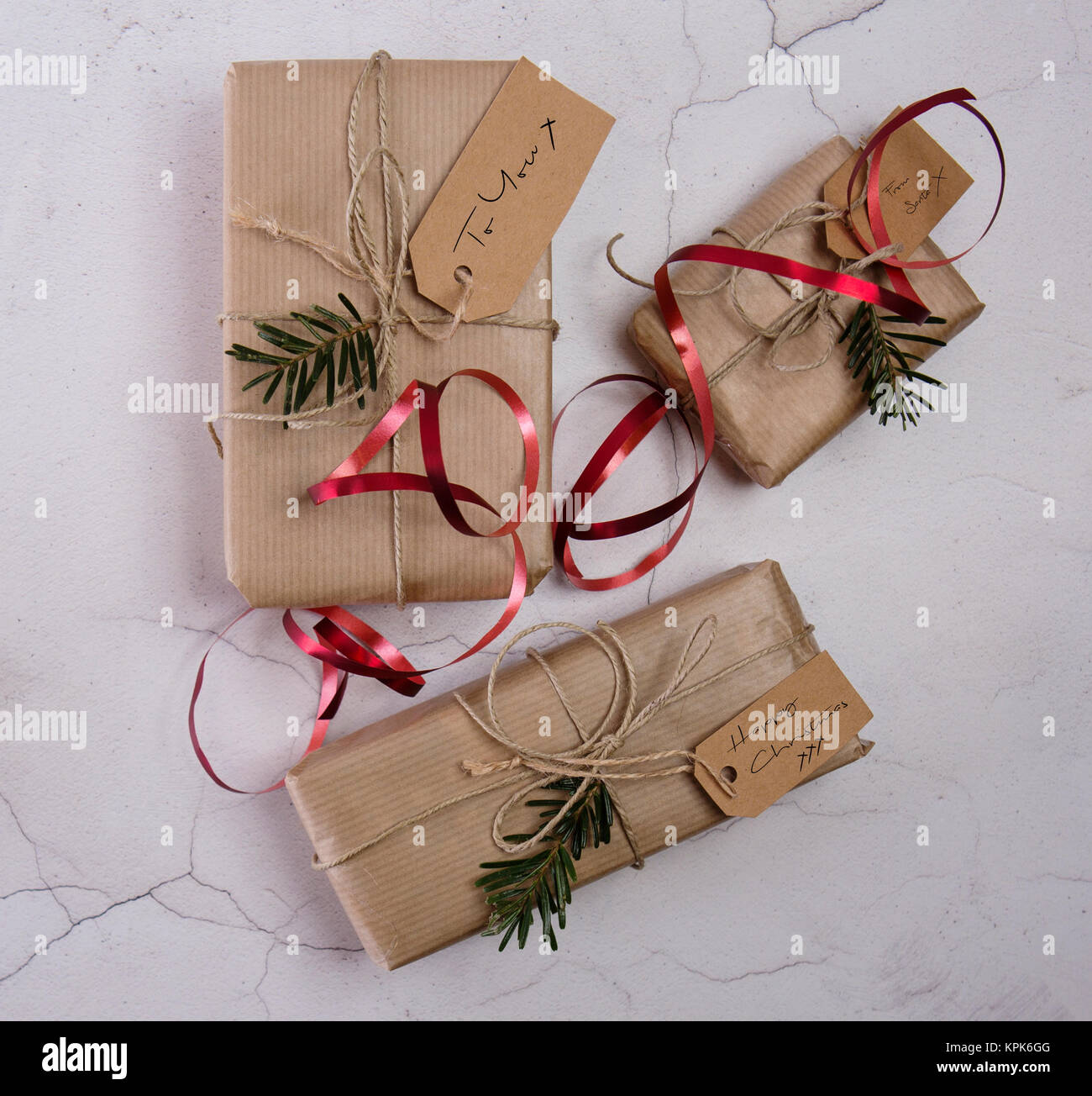 Selection of Christmas presents with lables tied with string and red ...