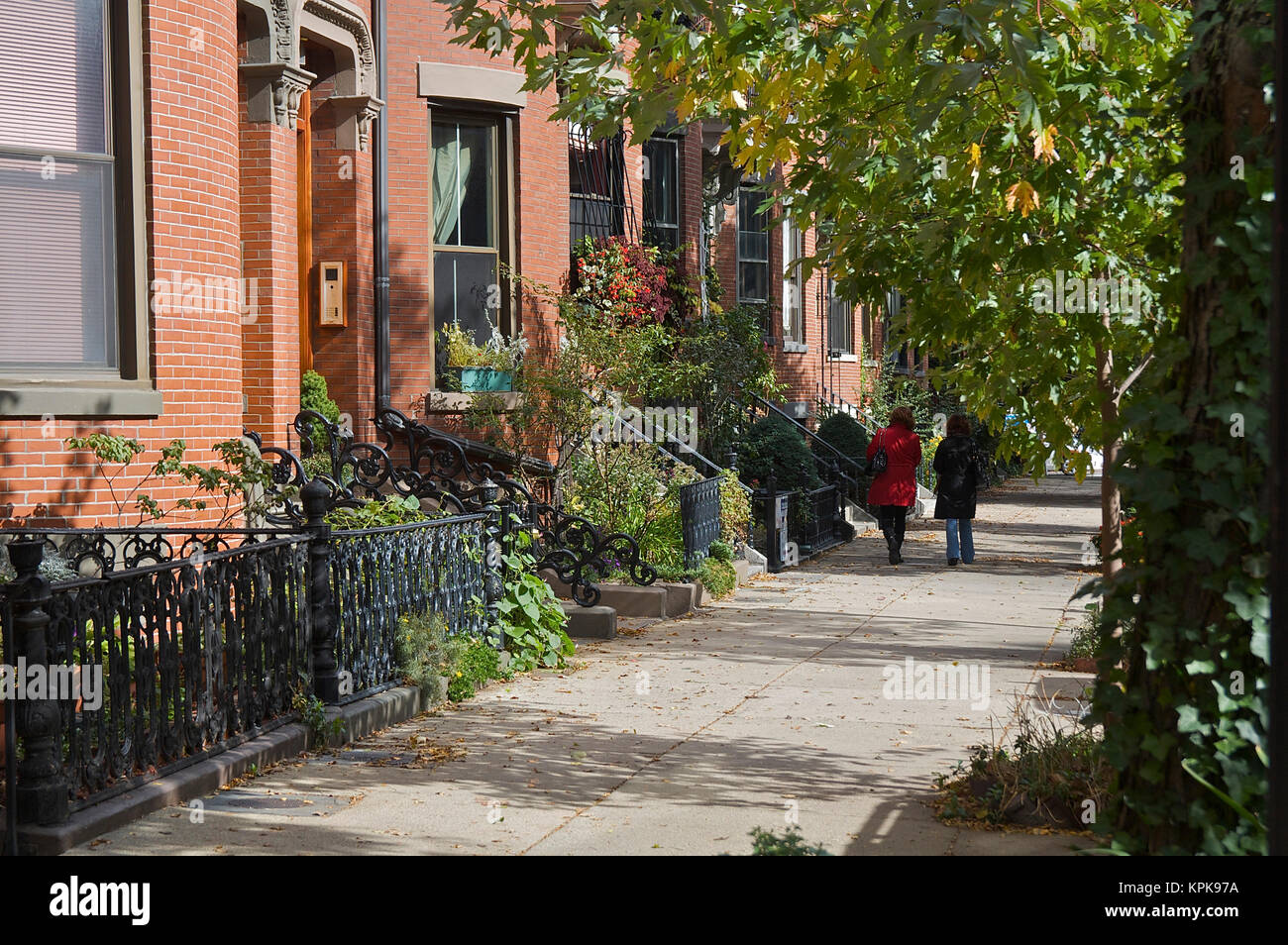 USA, Massachusetts, Boston. Two women walking on a sidewalk in Boston's ...