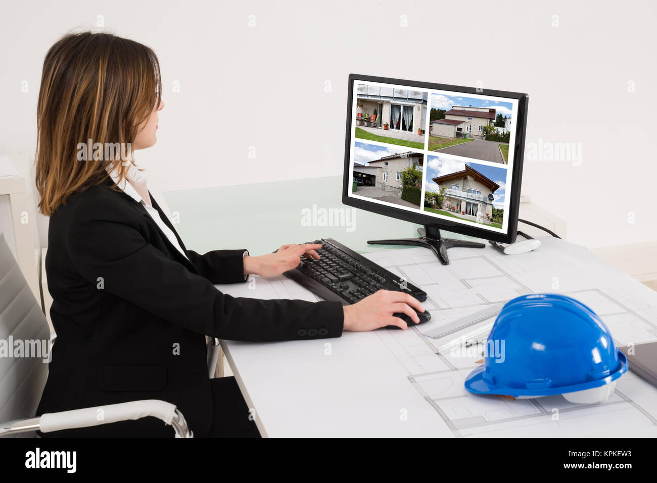 Female Architect Looking At Designs Of House On Computer Stock Photo ...