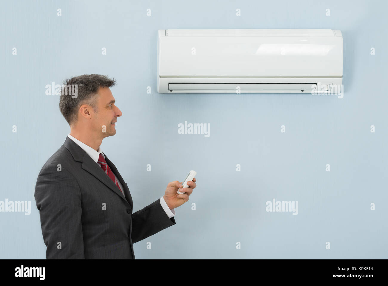 Businessman Holding Remote Control Air Conditioner In Office Stock ...