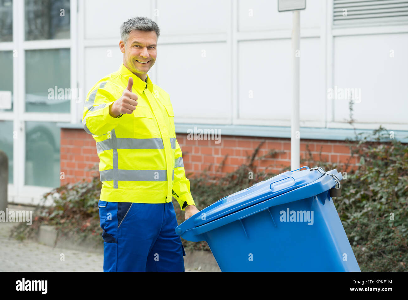 Working Man Holding Dustbin On Street Stock Photo - Alamy