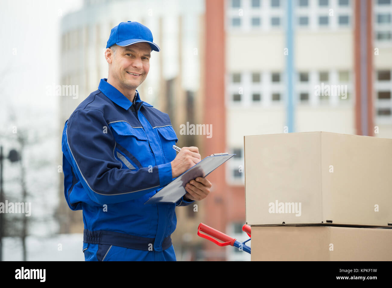 Portrait Of Delivery Man With Parcels And Clipboard Stock Photo - Alamy