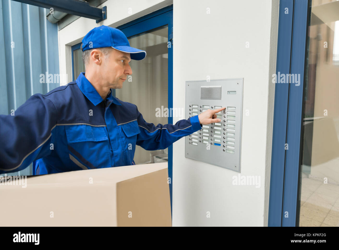 Delivery Man Pressing Button Of Intercom To Enter Building Stock Photo ...