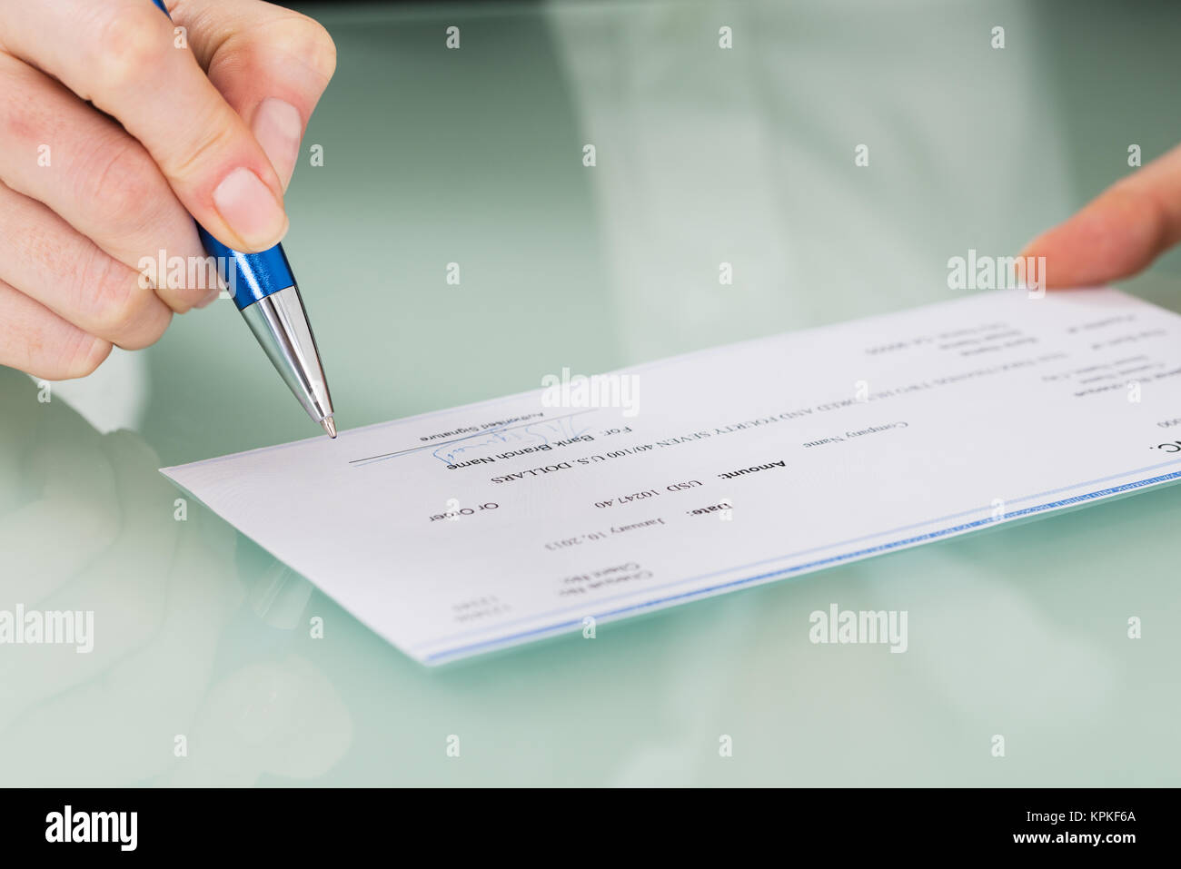 Businesswoman Hand Signing Cheque Stock Photo - Alamy