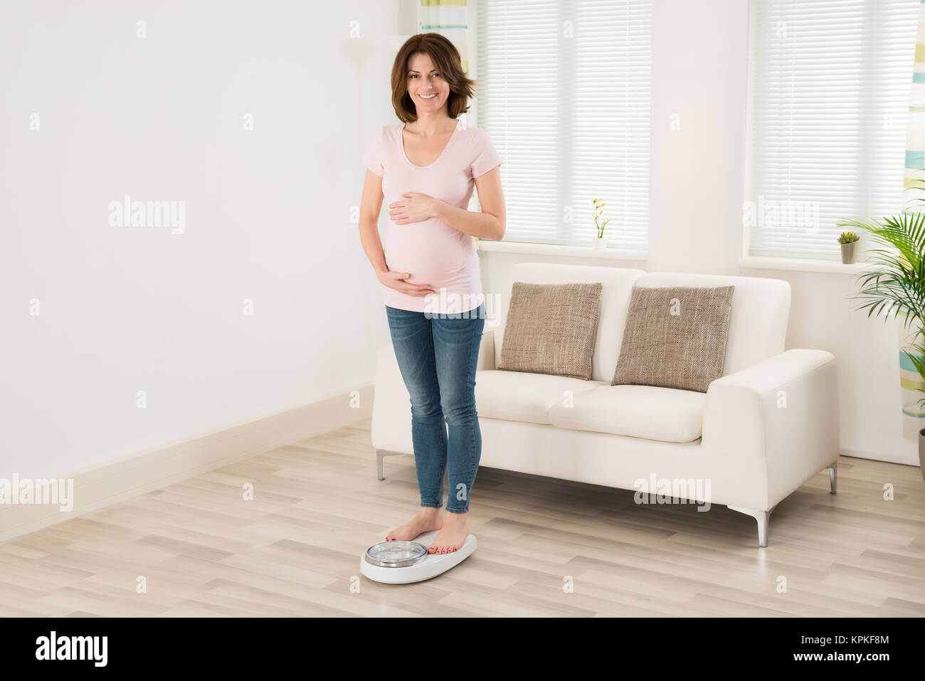 Pregnant Woman Measuring Her Weight Through Weighing Scale Stock Photo ...
