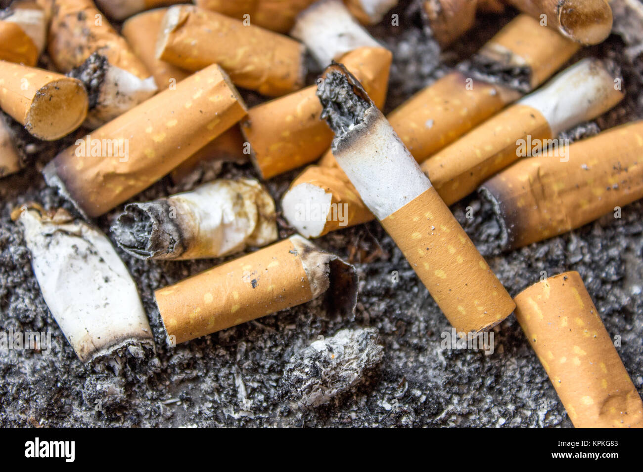 cigarette butts on a gray background Stock Photo - Alamy