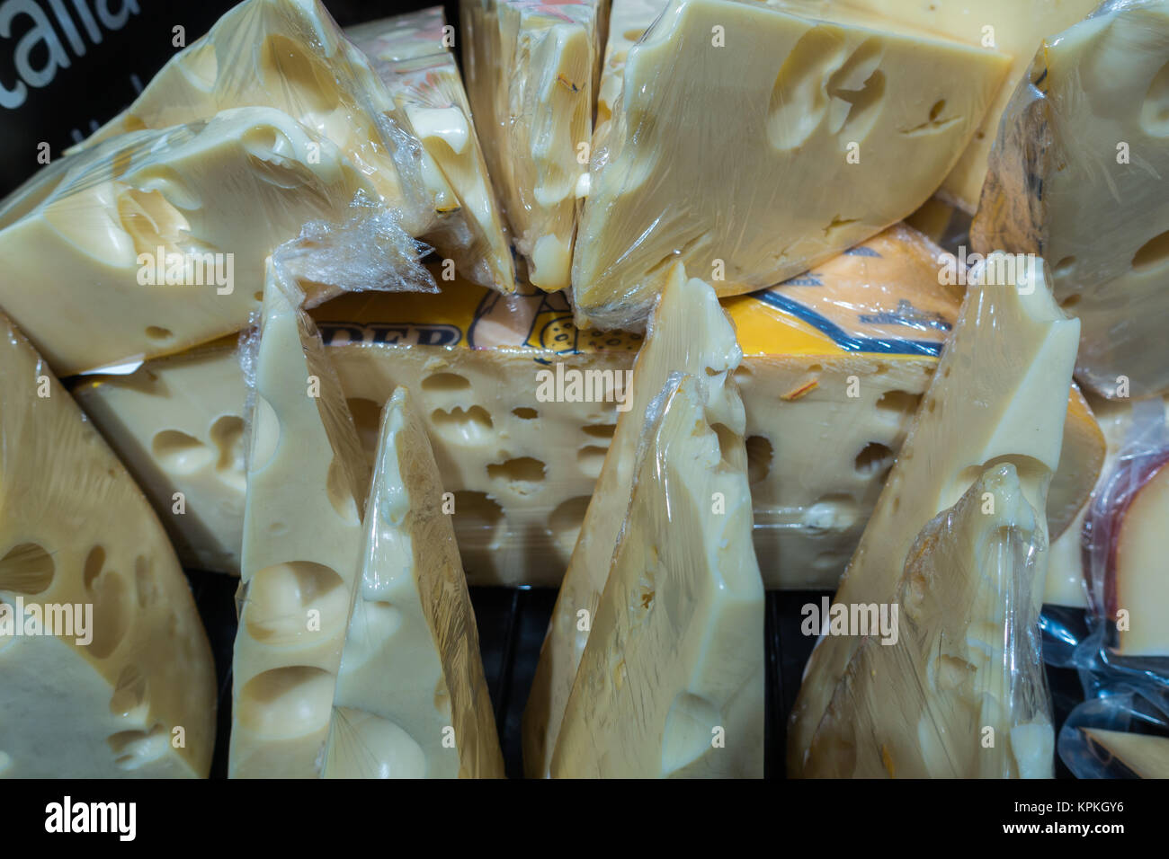 Maasdam cheese wrapped in cling film. Swiss-style Dutch cheese from the ...