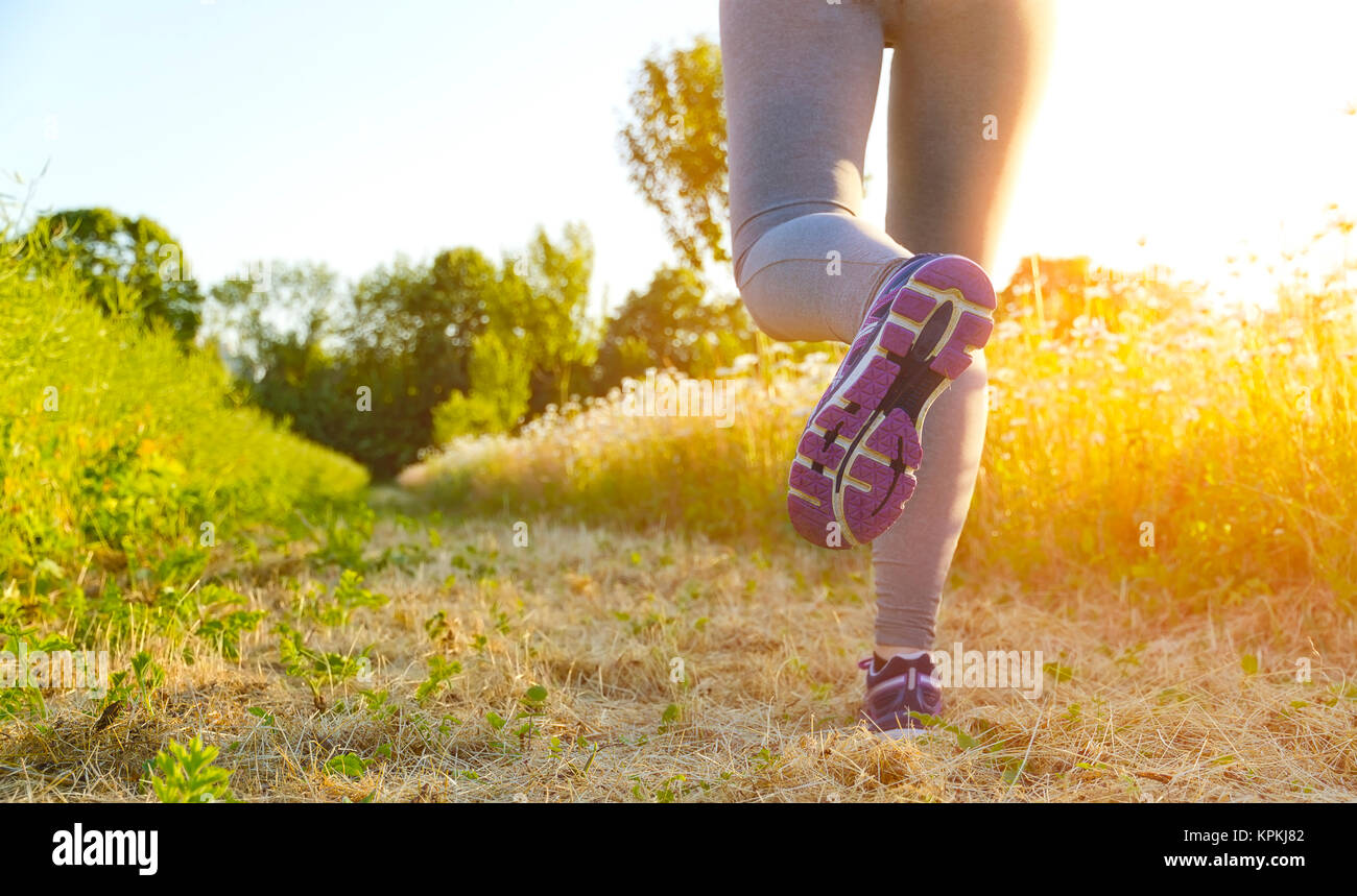 Woman running in a field Stock Photo - Alamy