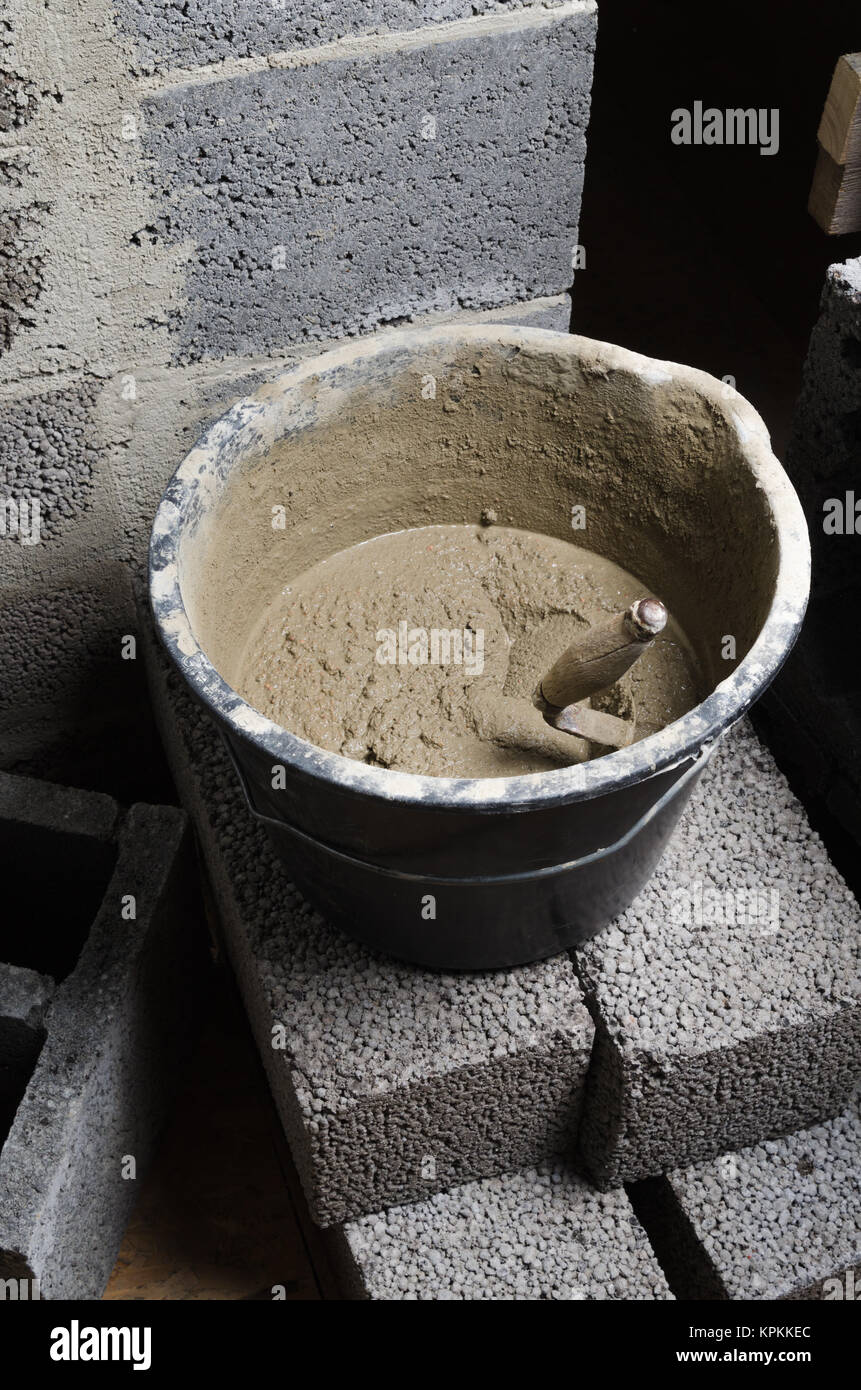 A bucket with a solution and a trowel, close-up Stock Photo - Alamy
