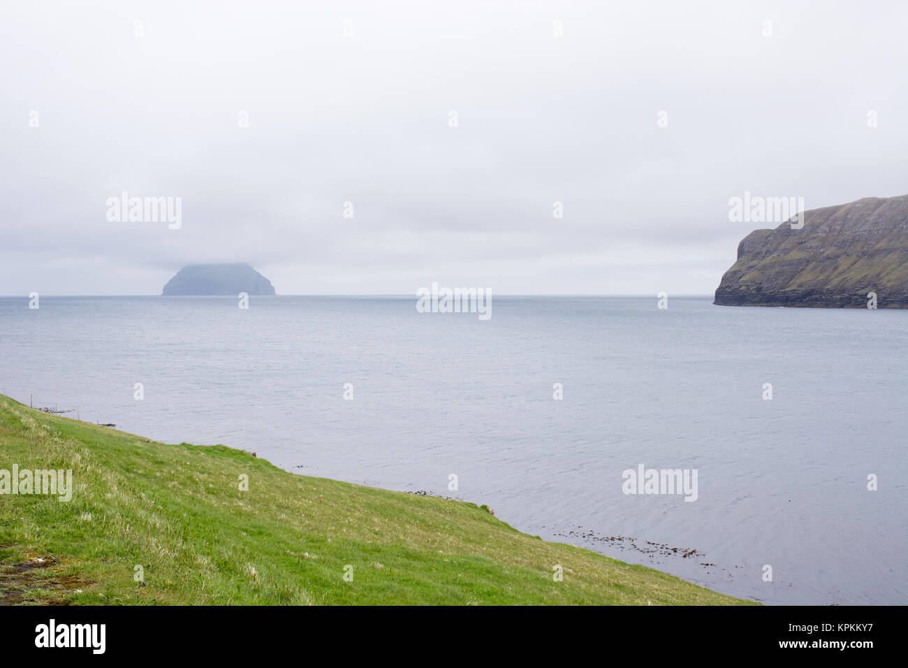 Typical landscape on the Faroe Islands, with green grass and rocks ...
