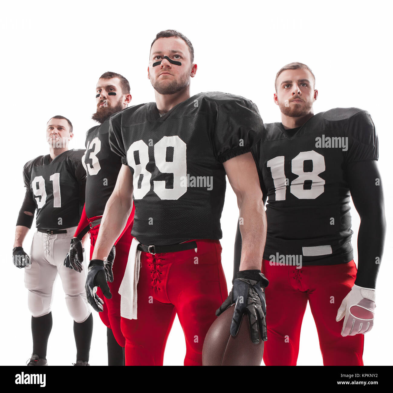 The four american football players posing with ball on white background ...