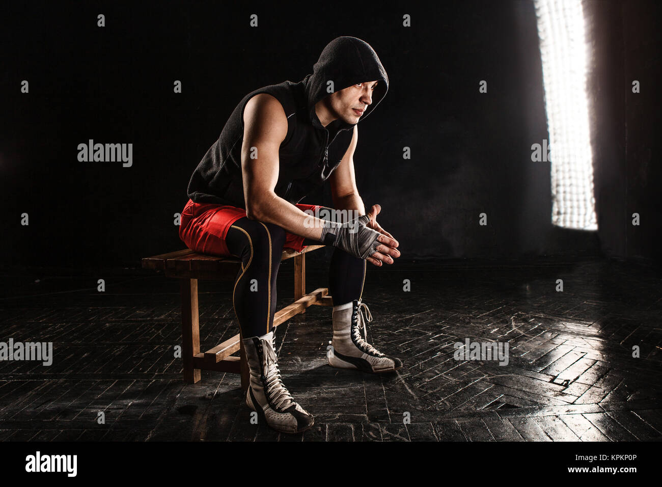 The muscular man sitting and resting on black Stock Photo - Alamy