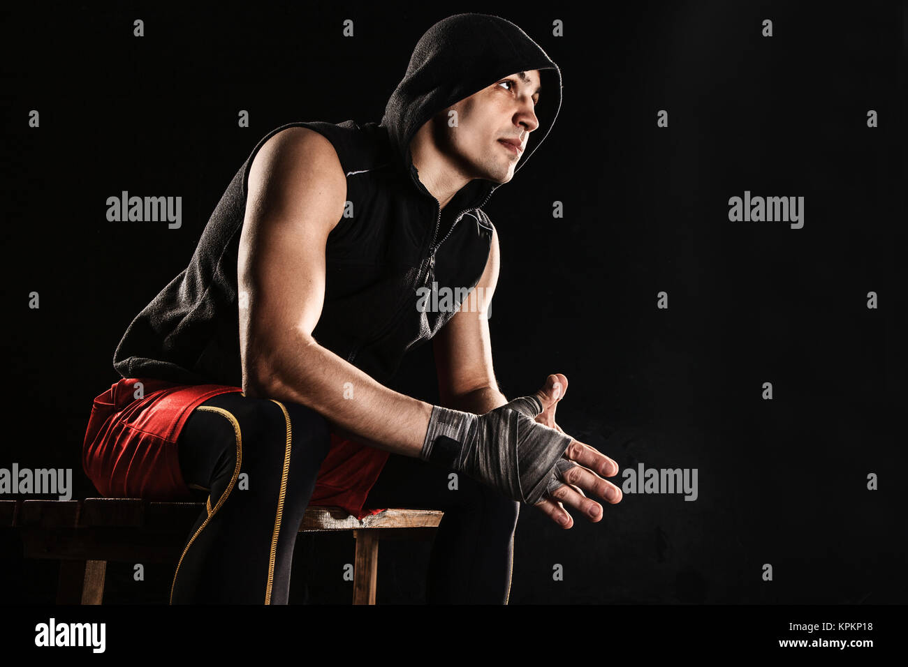 The muscular man sitting and resting on black Stock Photo - Alamy