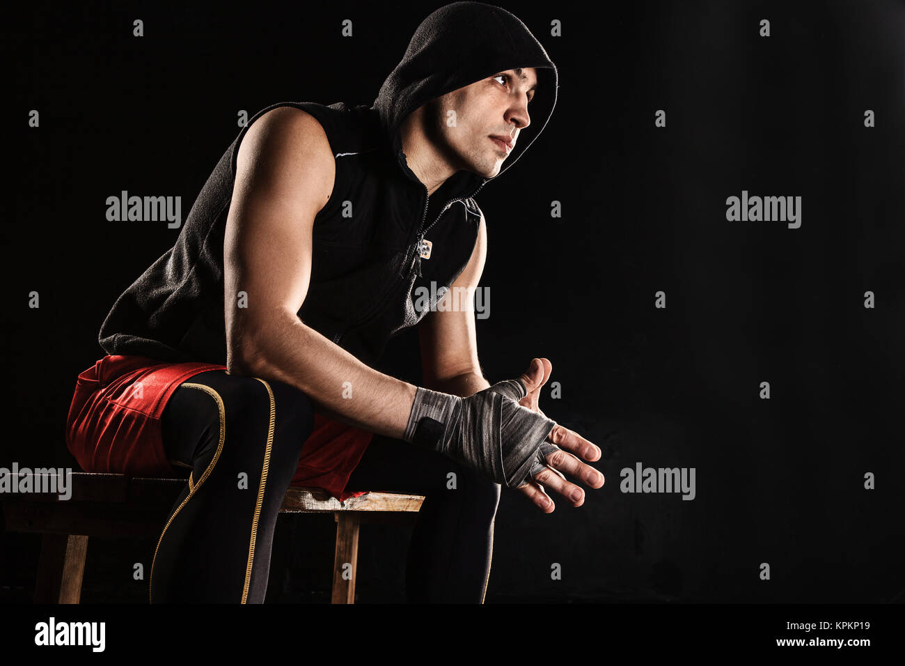 The muscular man sitting and resting on black Stock Photo - Alamy