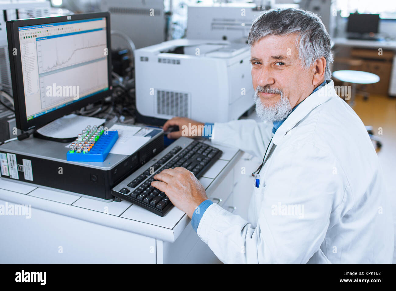Senior doctor using his tablet computer at work (color toned image ...
