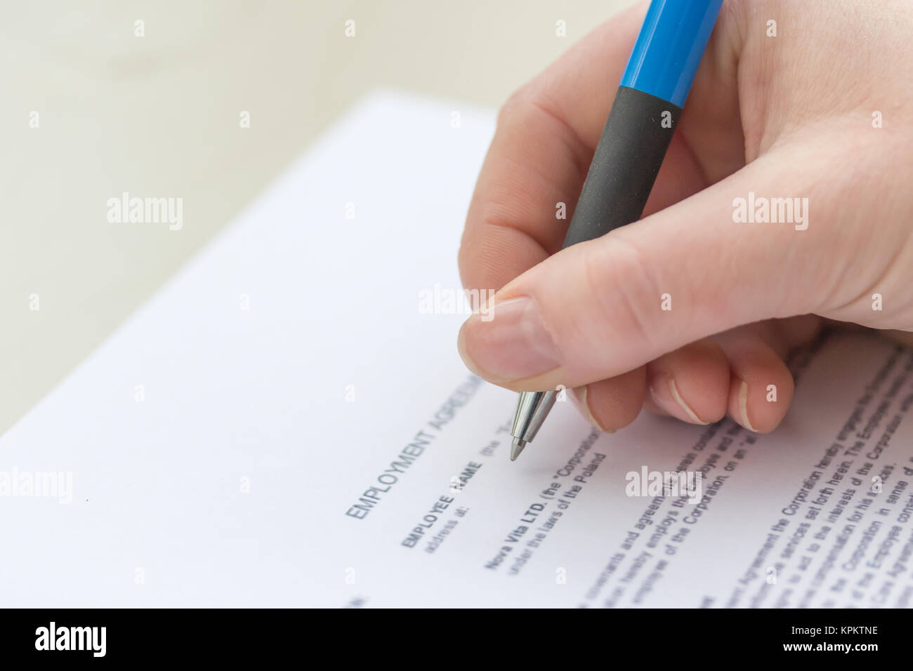 Hand filling employment agreement form Stock Photo - Alamy