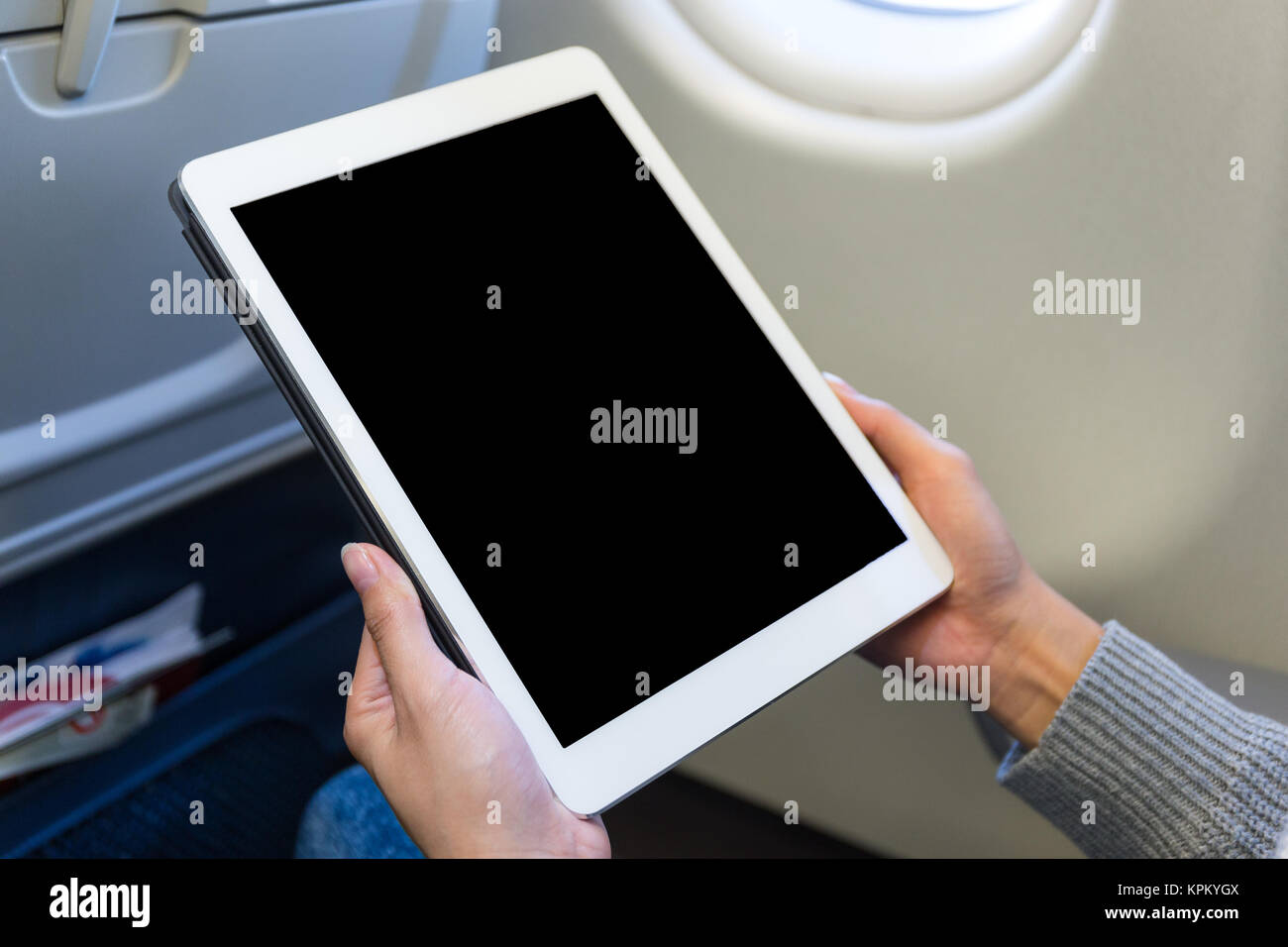 Woman use of the tablet in air plane Stock Photo - Alamy