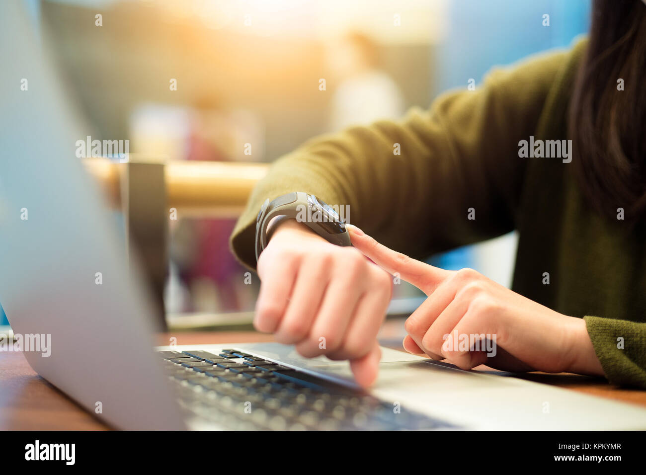 Woman connecting with smart watch and laptop computer Stock Photo - Alamy
