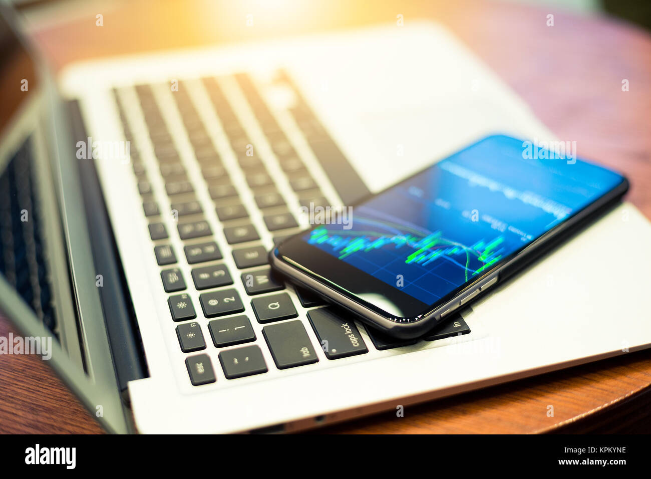Laptop computer and cellphone with stock market Stock Photo - Alamy