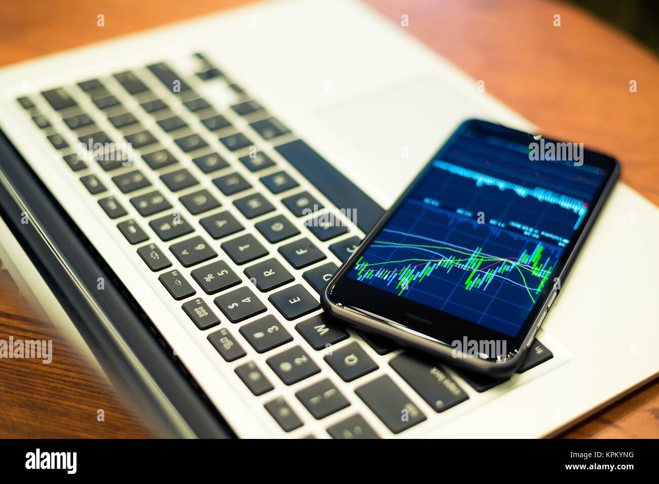 Stock market graph on cellphone with laptop computer Stock Photo - Alamy