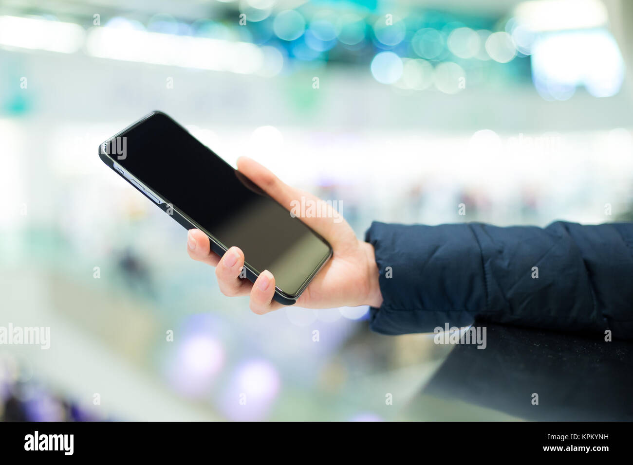 Woman holding cellphone in shopping mall Stock Photo - Alamy