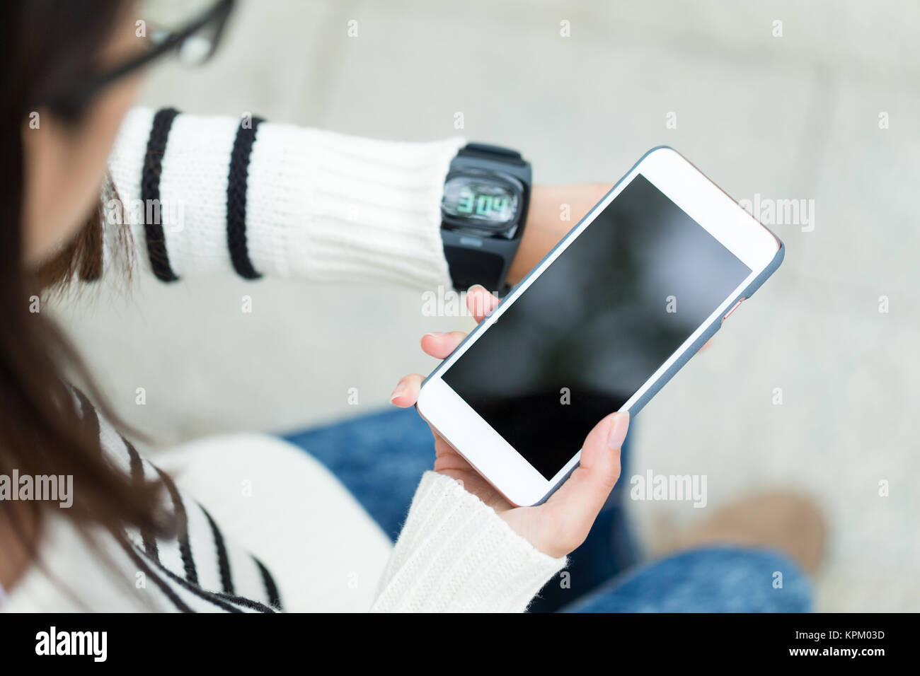 Woman connecting cellphone and smart watch Stock Photo - Alamy
