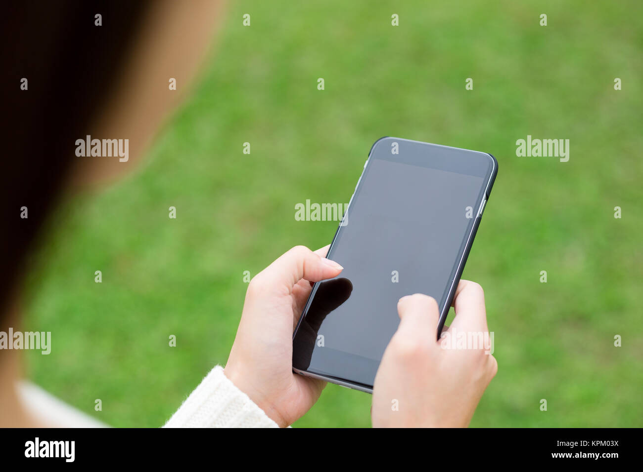 Woman use of cellphone over green grass Stock Photo - Alamy