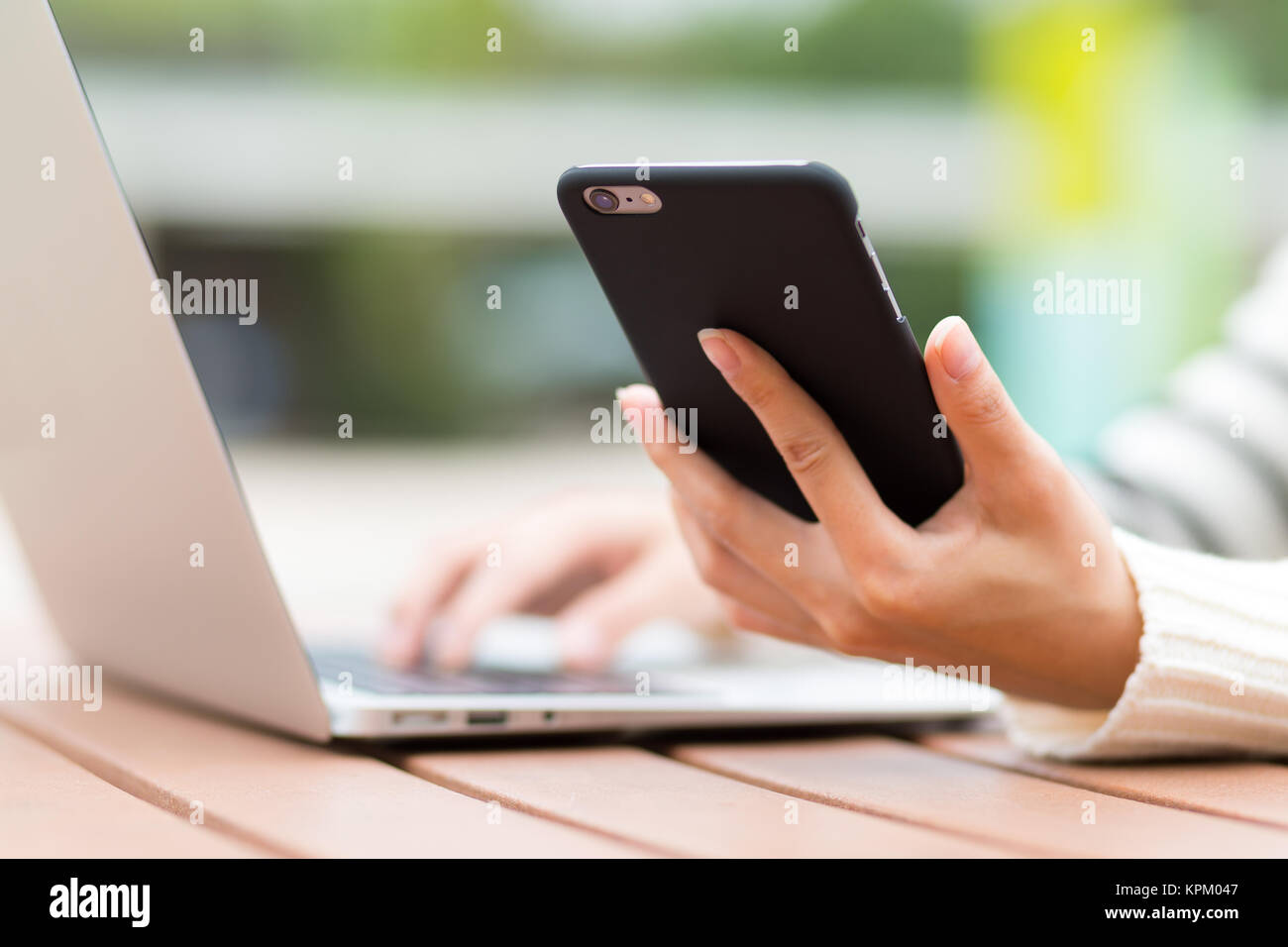 Woman use of cellphone and laptop computer Stock Photo - Alamy