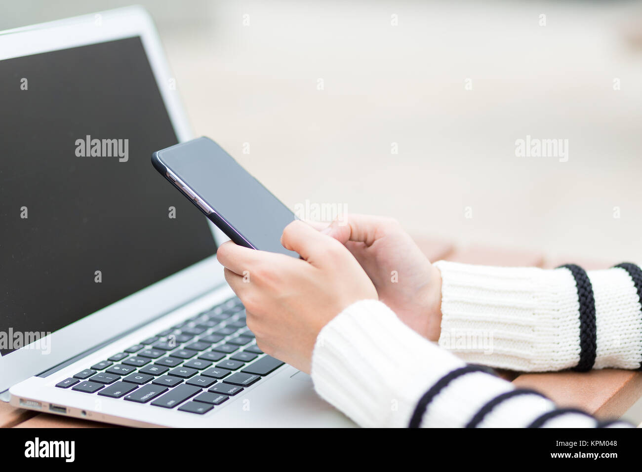 Woman use of cellphone and laptop computer Stock Photo - Alamy