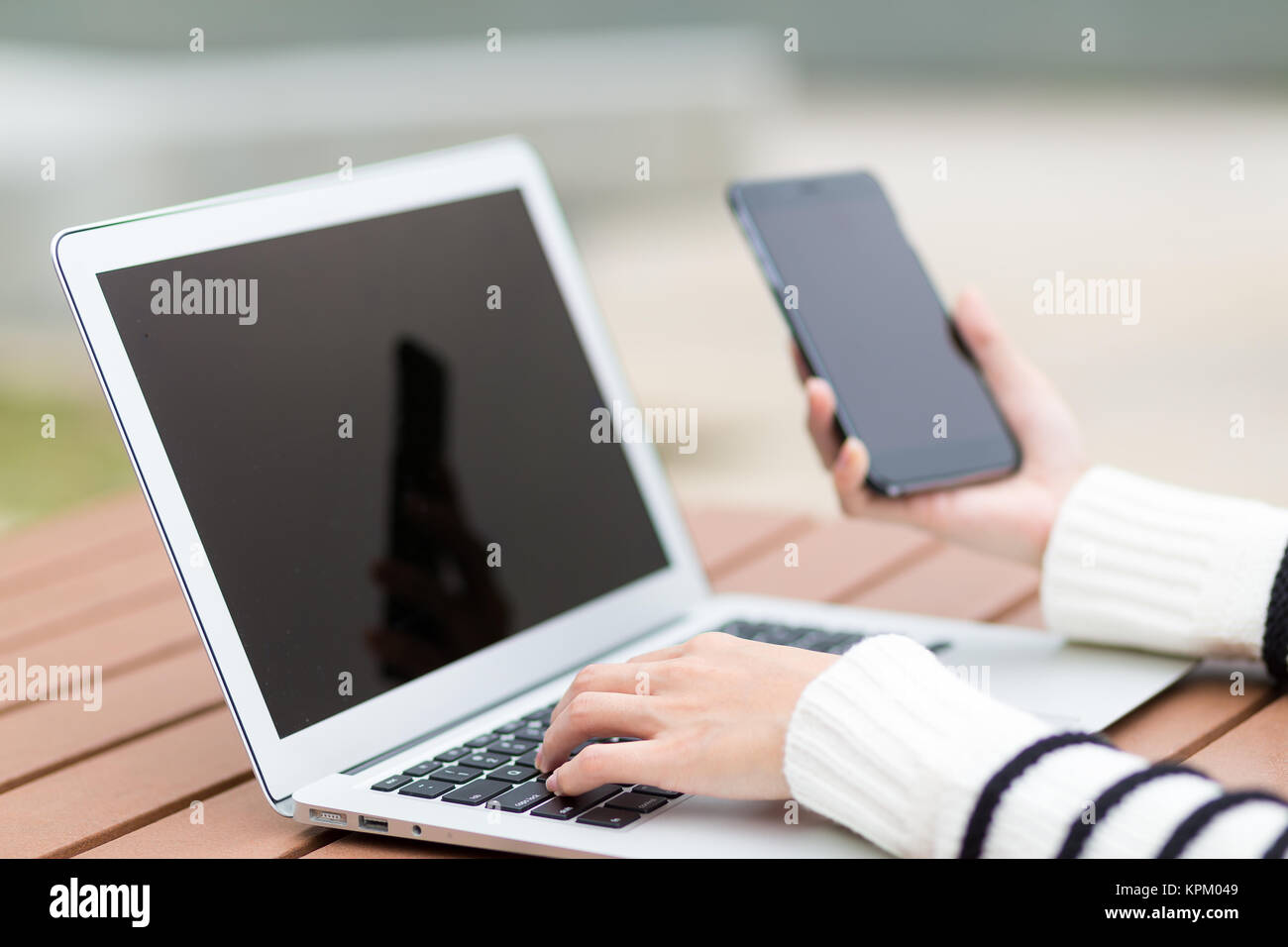 Woman use of laptop computer and cellphone Stock Photo - Alamy
