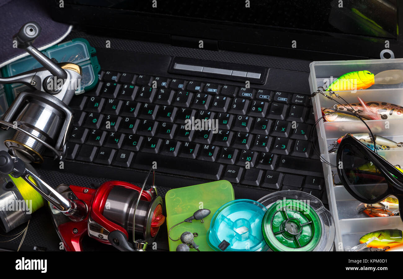 fishing tackles on keyboard a black notebook Stock Photo - Alamy