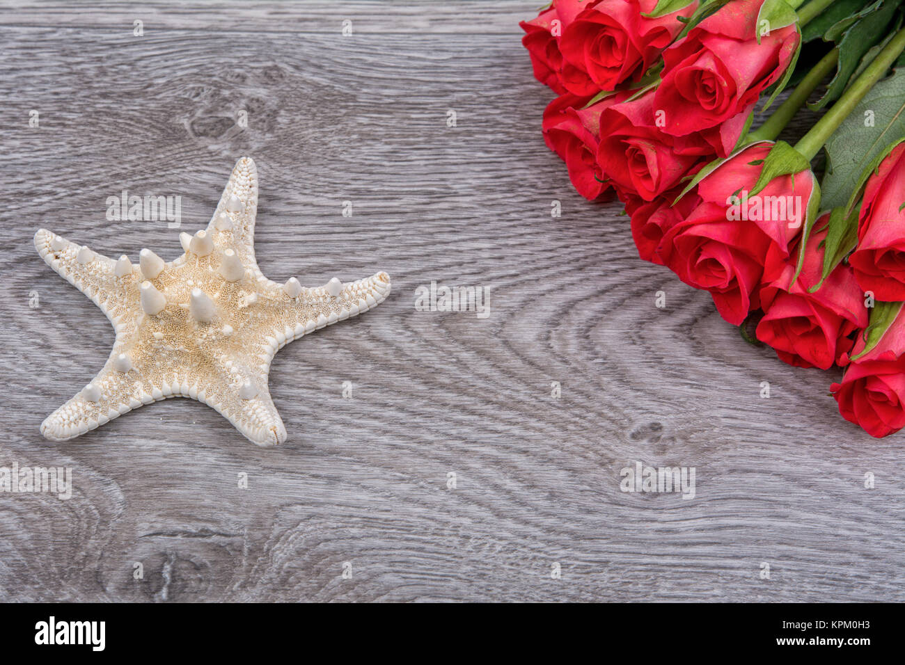 White starfish and roses on a wooden background Stock Photo - Alamy