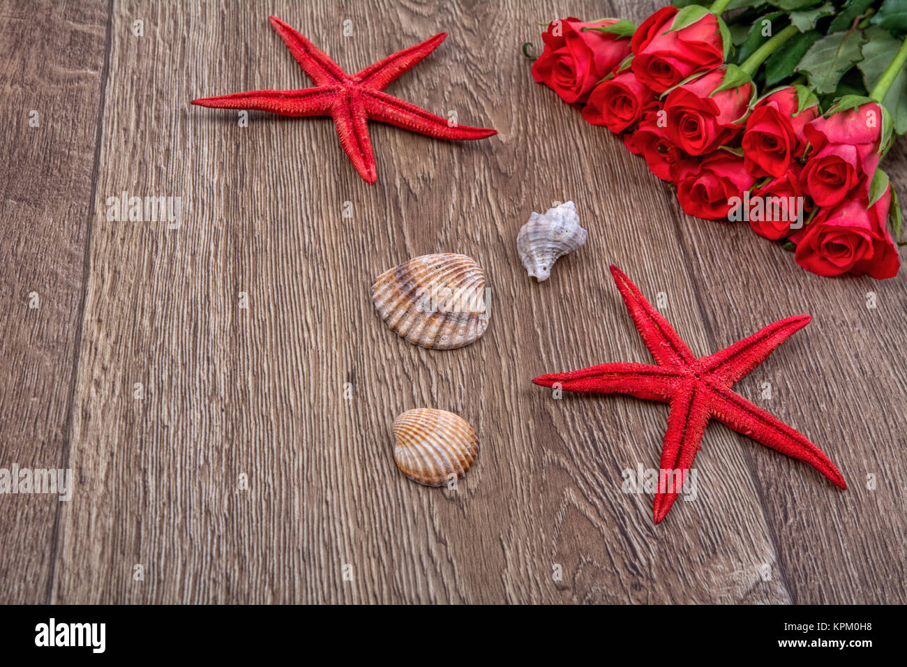 Starfishes, shells and red roses on a wooden background Stock Photo - Alamy