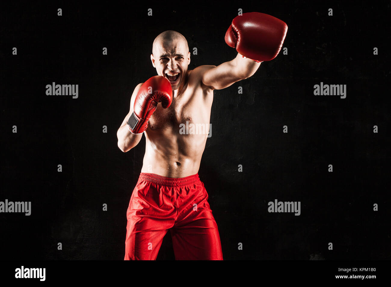 The young man kickboxing on black Stock Photo - Alamy