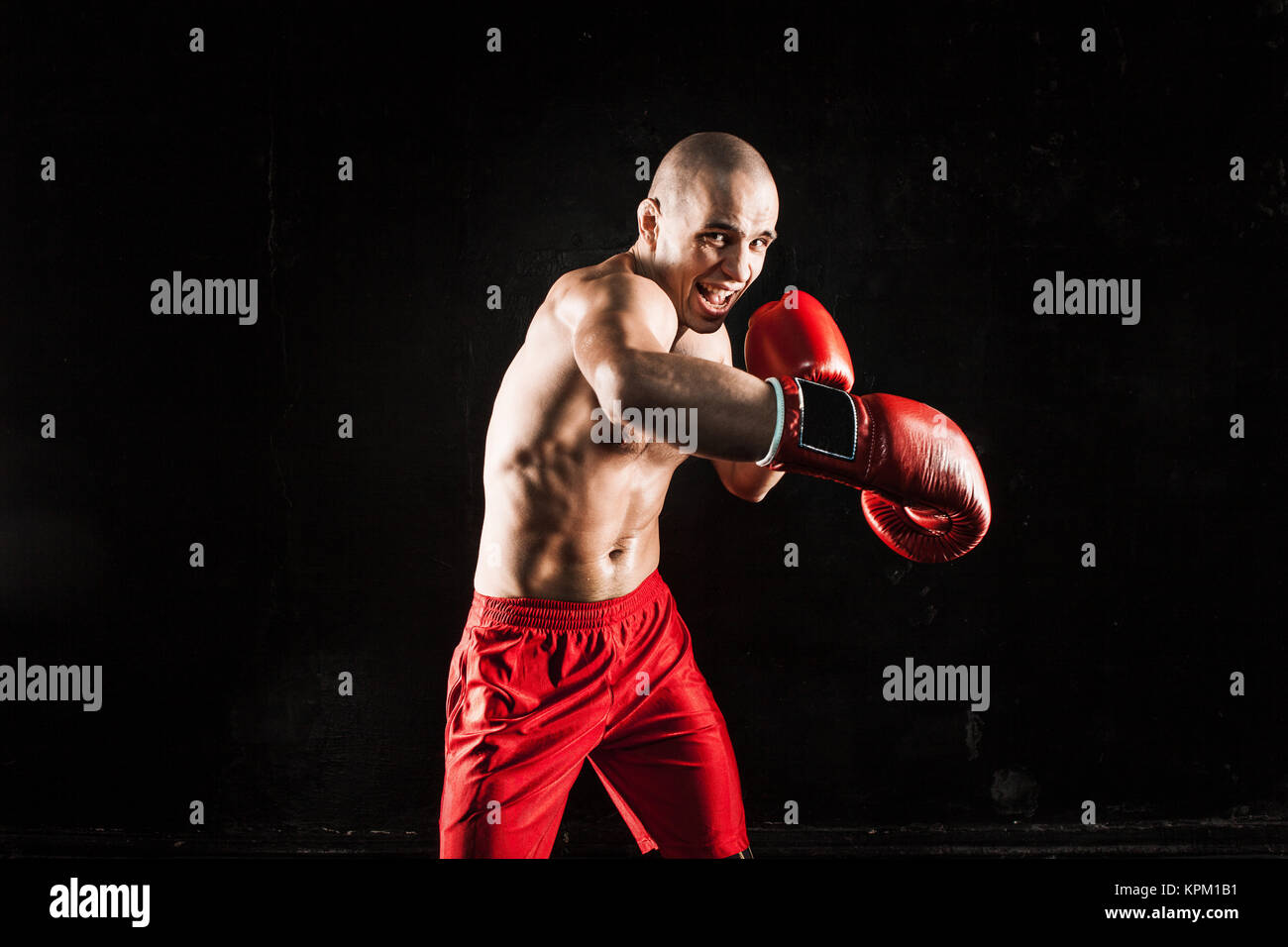 The young man kickboxing on black Stock Photo - Alamy