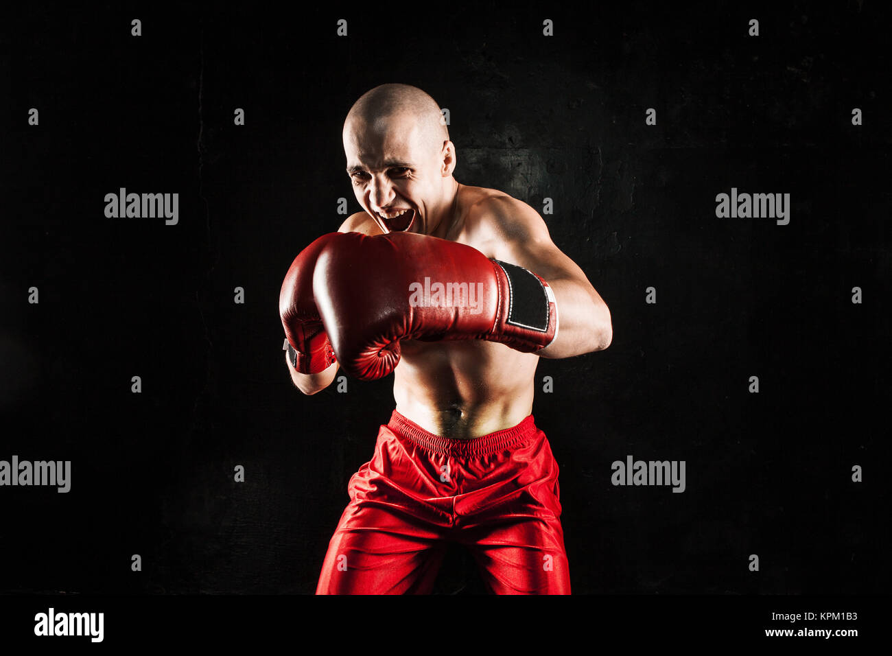 The young man kickboxing on black Stock Photo - Alamy