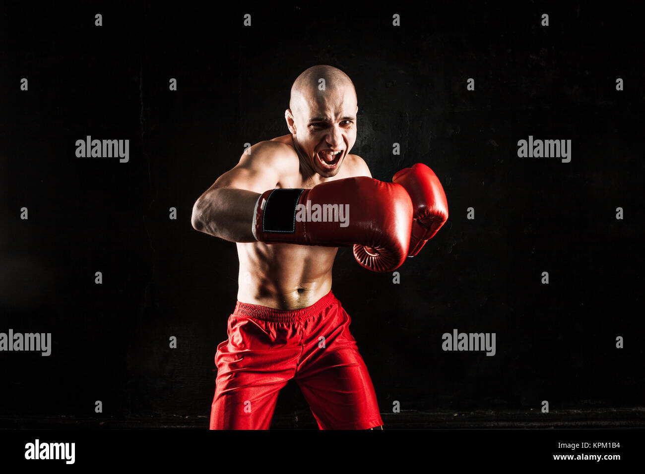 The young man kickboxing on black Stock Photo - Alamy