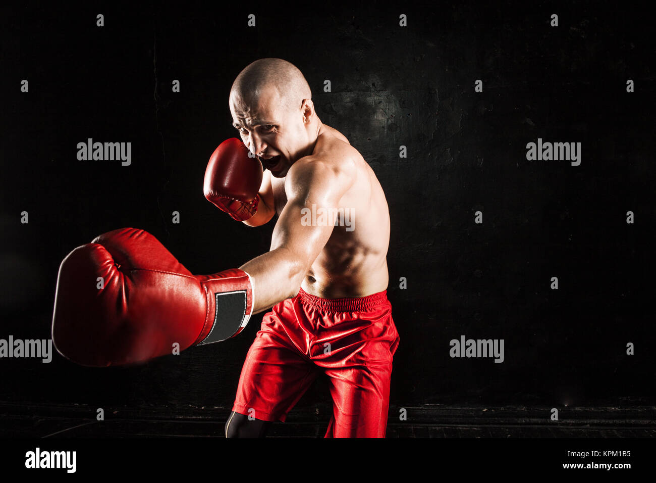 The young man kickboxing on black Stock Photo - Alamy