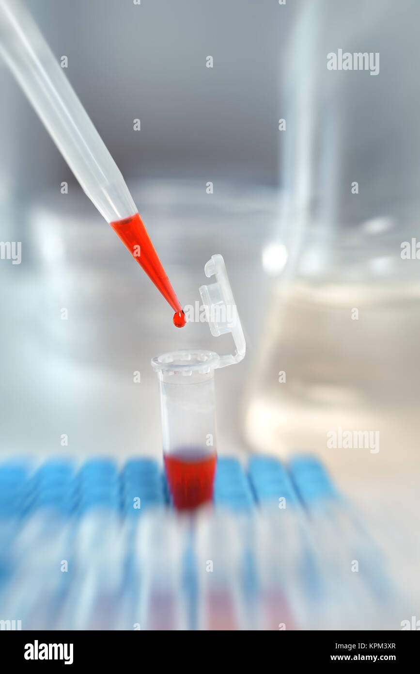 Scientific or medical background. Loading of red liquid sample with ...