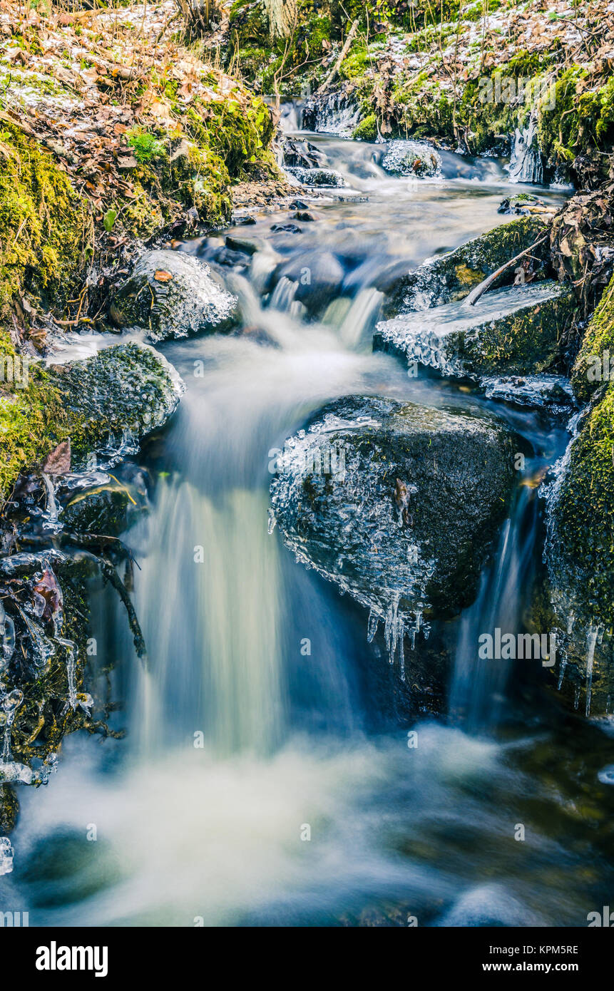 The flow of water in the spring of icicles and ice Stock Photo - Alamy
