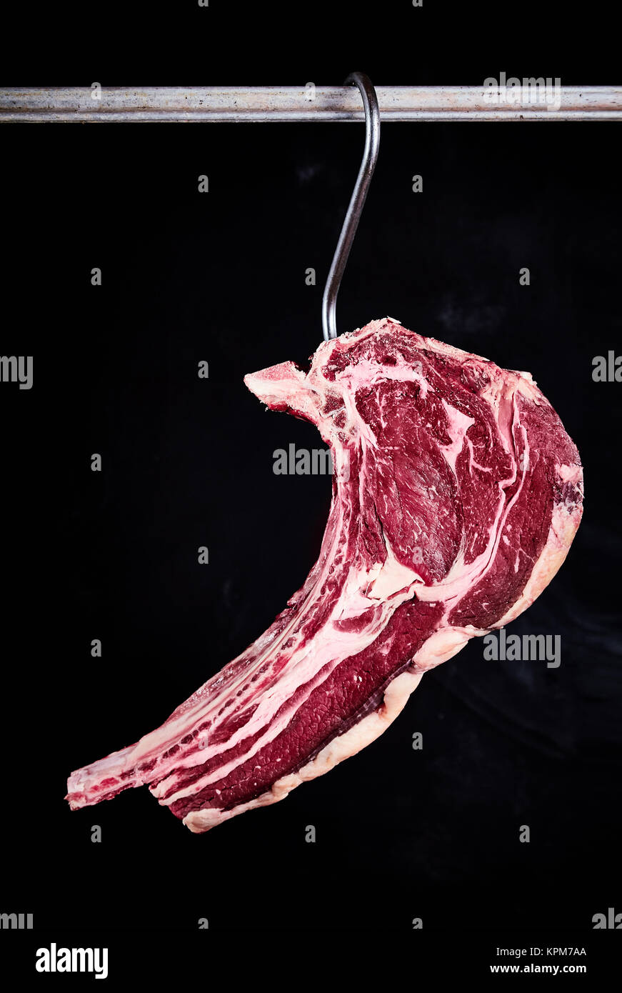 Fresh prime tomahawk beef steak hanging on a hook to mature at a ...