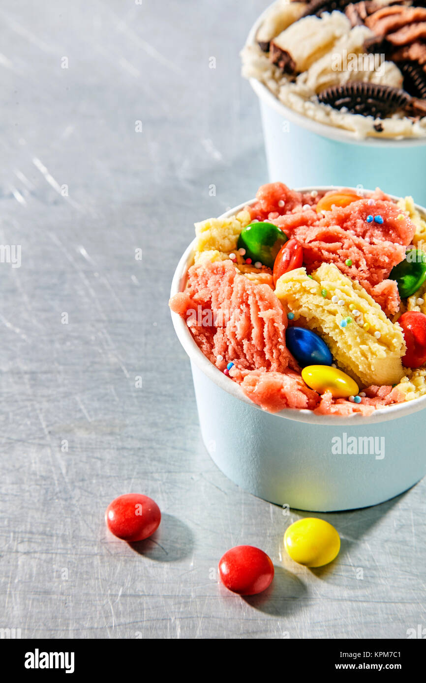 Off centered shot of colorful candy covered frozen dessert cup beside ...