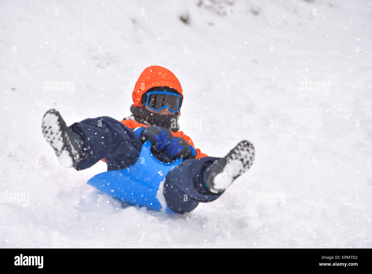 Little boy riding on snow slides in winter time Stock Photo - Alamy