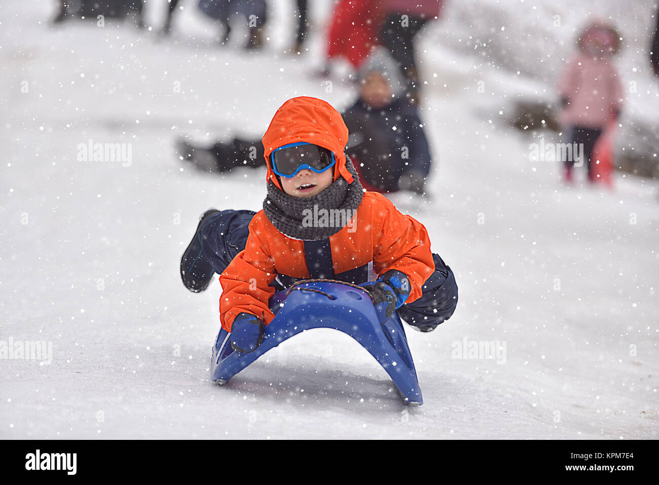 Little boy riding on snow slides in winter time Stock Photo - Alamy